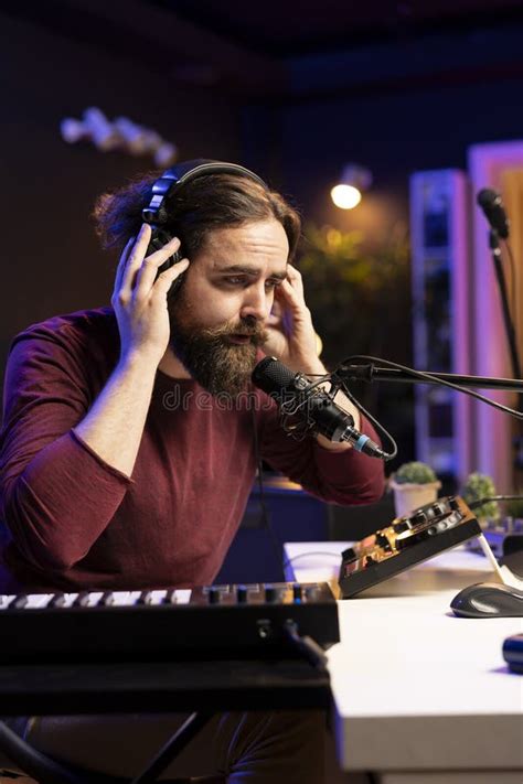 Young Sound Engineer Using Headphones To Do Audio Recording Session