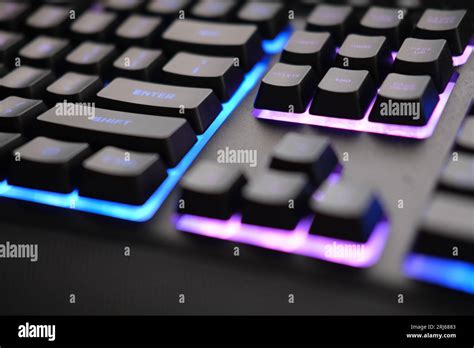 An Illuminated Computer Keyboard Featuring Keys Lit Up In Alternating Blue And Pink Hues Stock