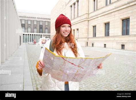 Redhead Girl Tourist Explores City Looks At Paper Map To Find Way For