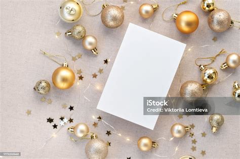 미적 겨울 휴가 비즈니스 브랜드 템플릿입니다 베이지색 배경에 빈 종이 카드 모형과 황금 장식 공 색종이 조각과 화환 조명 신년 축하 엽서 또는 초대장 크리스마스에 대한 스톡