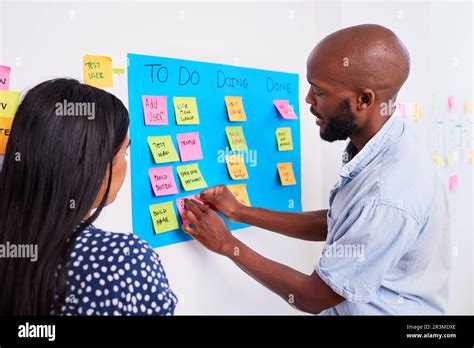 Two Developers Move Tickets On Scrum Board During Sprint Planning Stock