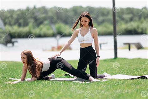 Two Beautiful Girls Do Exercises Outdoors In The Park Stock Image