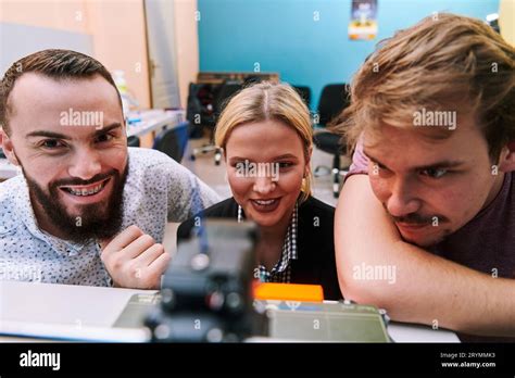 A Group Of Colleagues Working Together In A Robotics Laboratory Focusing On The Intricate