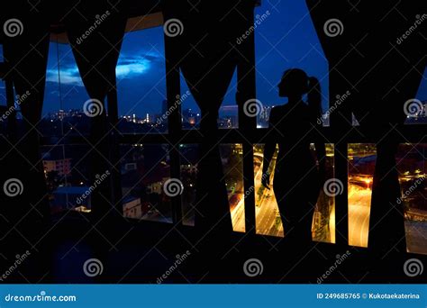 The Silhouette Of A Girl Against A Stained Glass Window Looks At The