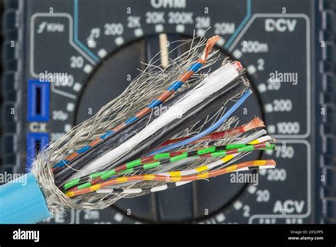 Stripped Cable With Several Colors In Front Of The Scale Of A Multimeter Multimeter Measures