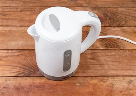 Small White Plastic Electric Kettle On An Old Wooden Table Stock Image