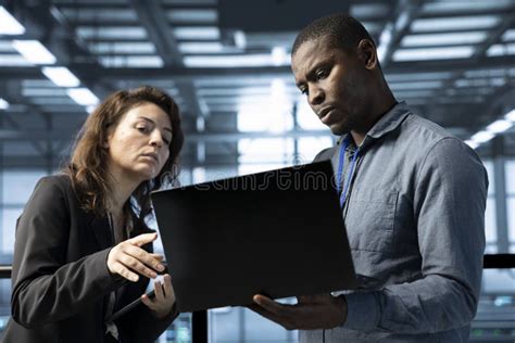 Teamworking Employees Examining Infrastructure In Data Center Stock