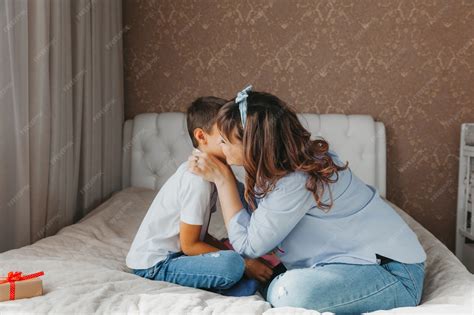 Maman Et Son Fils Sont Assis Sur Le Lit Sembrassent Et Samusent