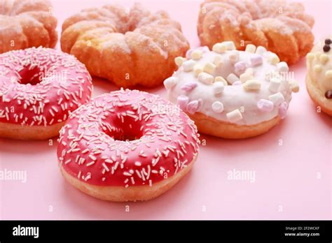 Various Types Of Donuts And Other Cakes On Pink Background Party Dessert Stock Photo Alamy
