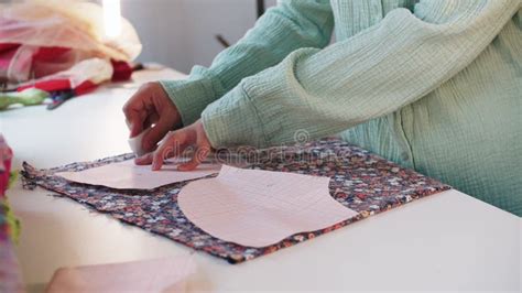 Female Designer Makes Marks On The Floral Fabric Using Paper Patterns