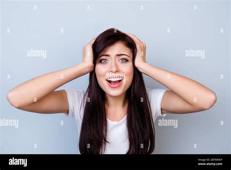 Close Up Portrait Of Young Shocked Woman Touching Her Head With Hands