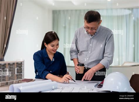 Two Architects Pointing On Blueprint To Analysis And Planning About Construction Building