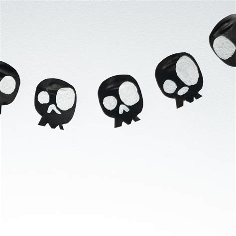 Skulls Cut Out Of Black Paper On A White Background Preparation For