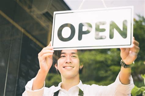 젊은 아시아 남자 고객을 환영 하 고 아침에 커피 숍을 열 오픈 라벨 플립 남성 아시아 바리스타가 거울을 보며 출입구에 커피 카페를 엽니다 20 24세에 대한 스톡 사진 및