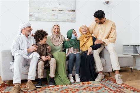 Alegre Familia Musulmana Multicultural Riendo En El Sofá En Casa 2024