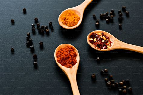 Three Wooden Spoons Filled With Spices On Top Of A Table Photo