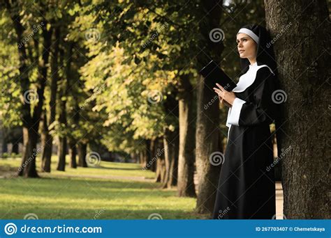 Young Nun Reading Bible In Park On Sunny Day Space For Text Stock