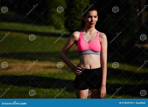 Beautiful Sporty Girl In Bright Sportswear Standing In The Park On