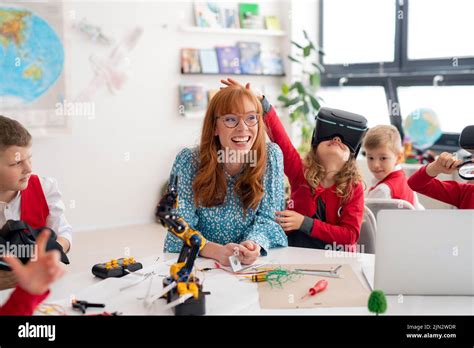 Happy Schoolgirl Wearing Virtual Reality Goggles At Class Having Fun