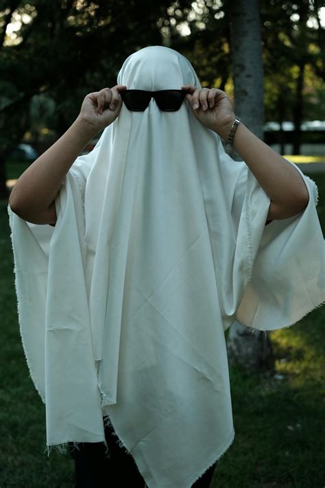 A Person Dressed As A Ghost Wearing A White Sheet And Sunglasses · Free