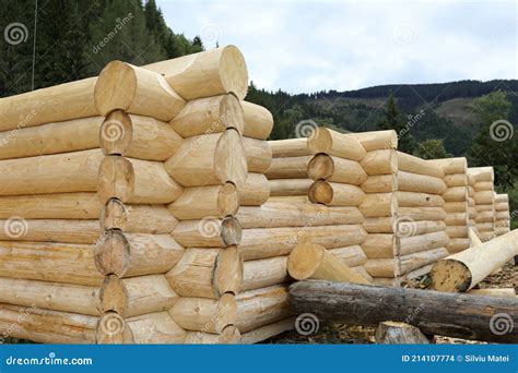 Assembly Of A Wooden Log House On Construction Site In The Middle Of