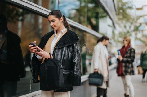 Businesswomen Connect Through Mobile Phones While Standing Outdoors In Urban Surroundings Stock