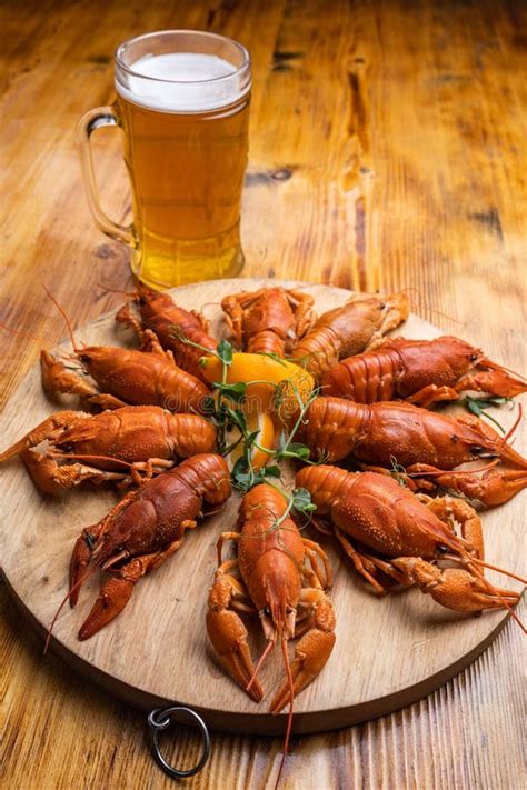 Boiled Crayfish With Lemon Dill And Herbs On A Wooden Cutting Board On