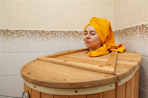 그녀의 머리에 노란색 수건으로 난방 및 건강 개선 절차 동안 삼나무 배럴 사우나에서 백인 외관의 젊은 아름다운 소녀 건강 및 미용 건강관리와 의술에 대한 스톡 사진 및 기타