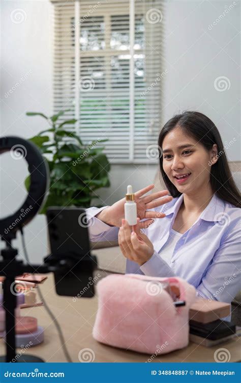 Asian Woman Showcasing Product In Beauty Tutorial Video Stock Image