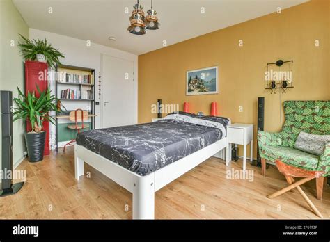 A Bedroom With A Bed Chair And Books On The Shelfs In Front Of The Bed