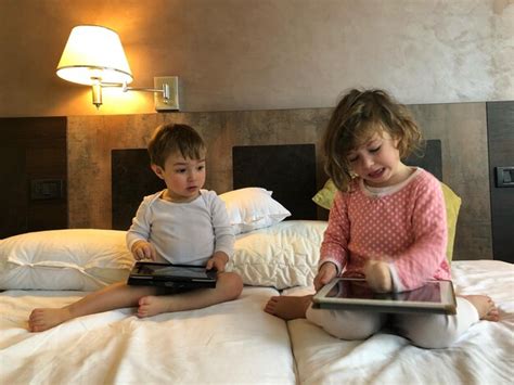 Premium Photo Siblings Using Digital Tablet On Bed At Home