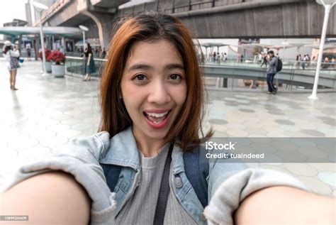 Young Attractive Asian Woman Tourist Taking A Photo Of Selfie In Urban