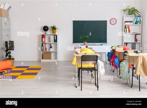Interior Of Classroom With Chalkboard Desks And Shelf Units Stock