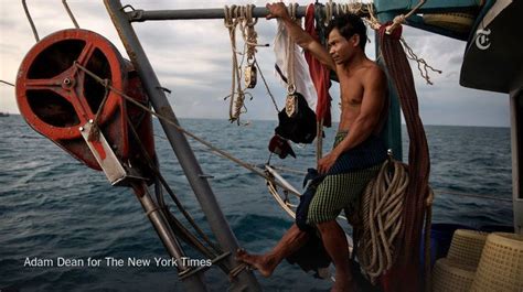 A Man On The Deck Of A Boat With Ropes Hanging From Its Rig