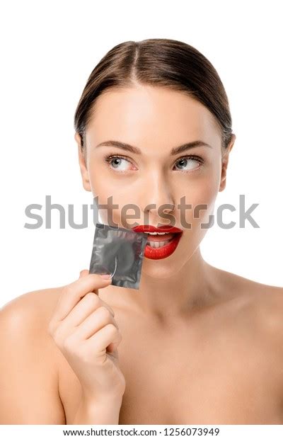 Attractive Naked Girl Holding Condom Looking 스톡 사진 1256073949