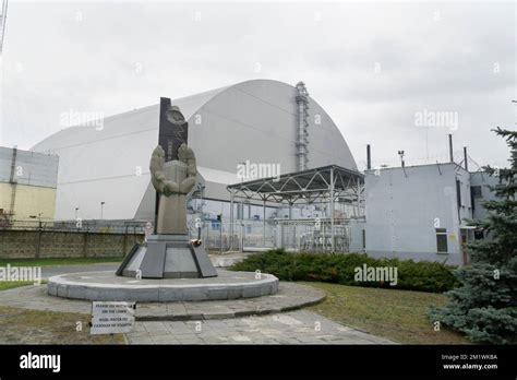 Liquidators Memorial Monument With Nuclear Chernobyl Plant Behind Them