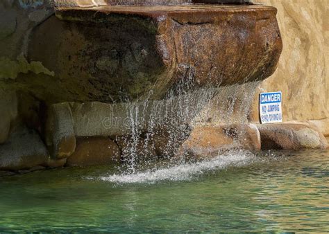 A Waterfall At A Resort Swimming Pool With A Warning Sign Stock Image Image Of Adventure Rock