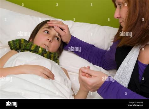 Mutter Sitzt Am Bett Von Krankem Sohn Sick Son In Bed Model Released Stock Photo Alamy