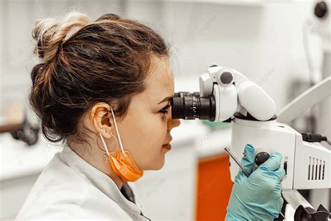 Dentist Examines Teeth Under Microscope With Advanced Equipment Photo Background And Picture For
