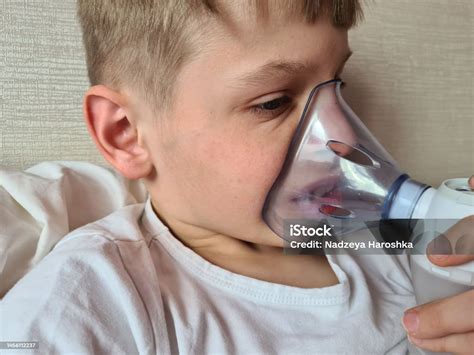 마스크 증기 흡입기를 들고 증기 분무기를 통해 천식 호흡을 치료하는 십 대 소년 아이 전자담배에 대한 스톡 사진 및 기타 이미지
