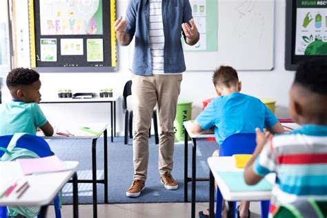 Premium Photo Low Section Of Male Teacher And Diverse Pupils At Desks