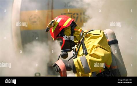 Male Firefighter In The Helmets And Uniform With Smoke On The
