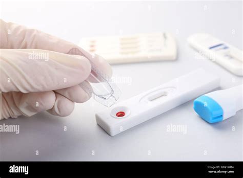 Doctor Dropping Buffer Solution Onto Disposable Express Test Cassette