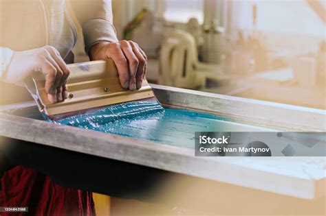 세리그래프 인쇄 생산 실크 스크린 섬유 프린터 수동 화면 인쇄 디자인 스튜디오 스퀴지와 남성 손의 사진 실크 스크린에 대한 스톡