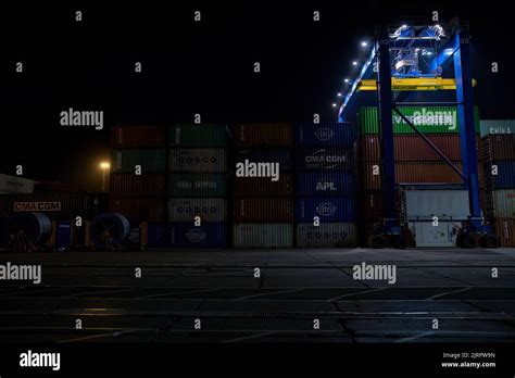 Operation Of Container Terminal At Night Unloading Container Ship At Night Stacks Of