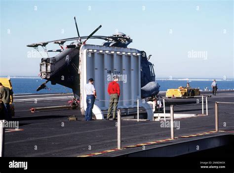 Crew Members Stand Beside An Open Magazine Elevator On The Flight Deck