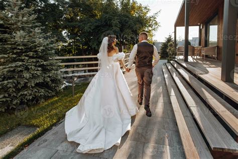 The Bride And Groom Walk After The Wedding Ceremony In A Beautiful