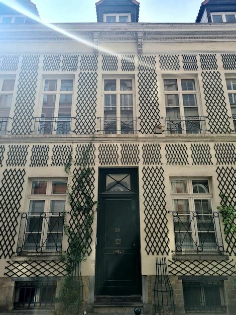 Un Edificio Con Una Puerta Negra Y Una Celosía Blanca En El Frente Foto Premium