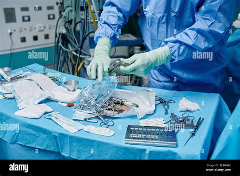 Crop Anonymous Surgeon In Gown And Latex Gloves Choosing Various
