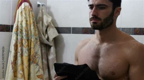 Attractive Muscular Young Man Undressing Taking Off Black Tank Top In